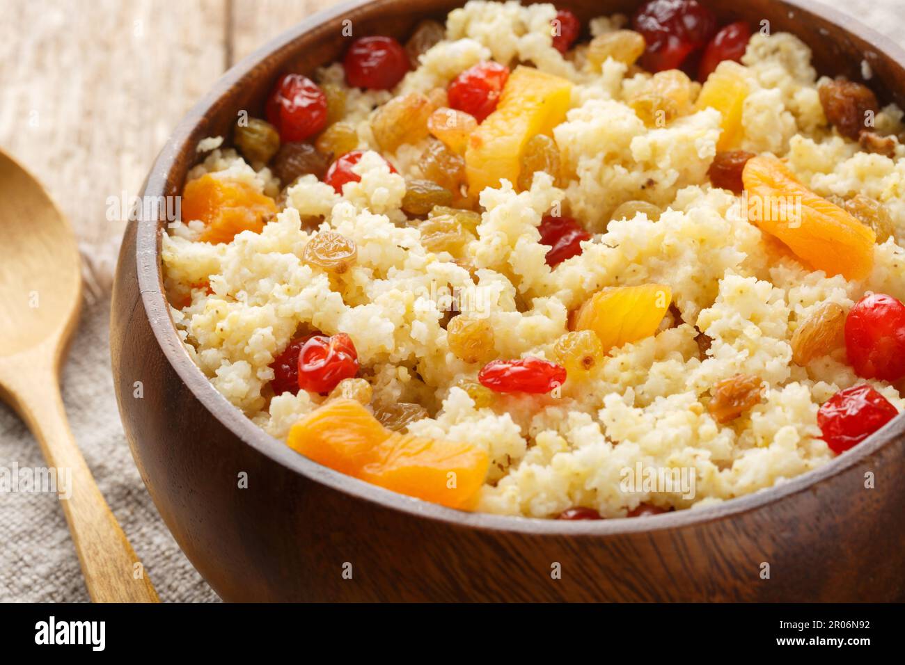 Millet with dried fruits and berry close-up in a bowl on the table ...