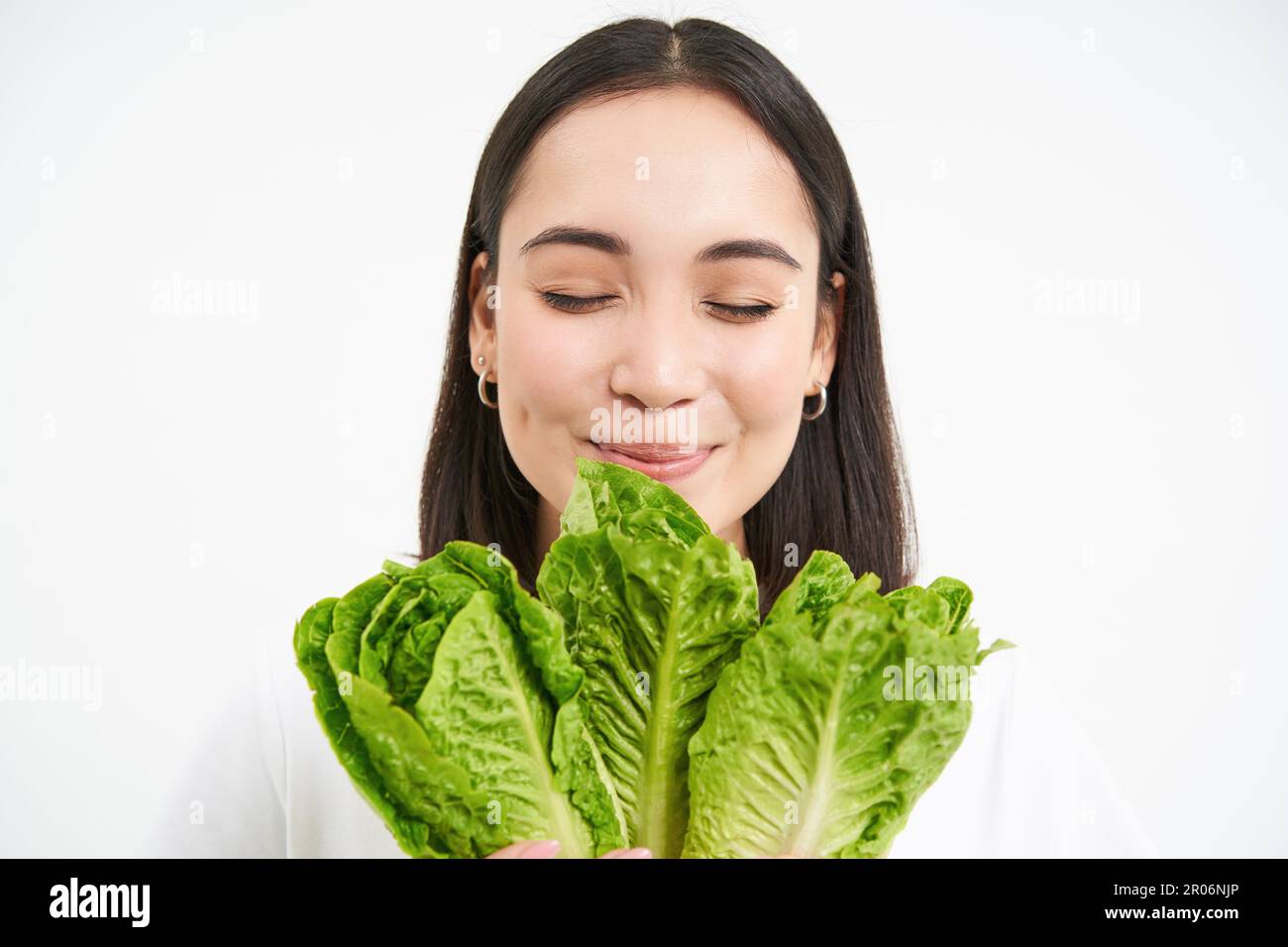 Close up portrait of happy korean woman, shows her face with lettuce ...