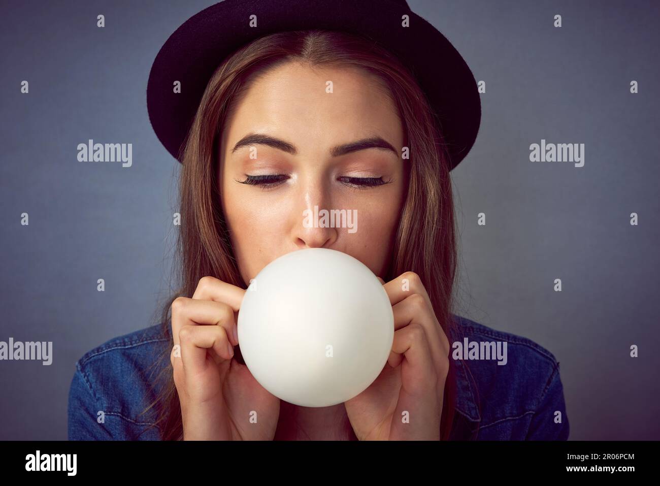 Dont let go of your silly side. a fun-loving young woman blowing up a ...