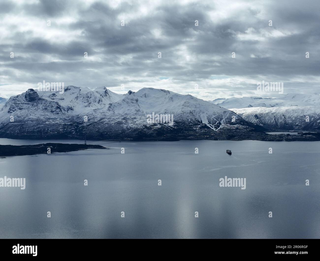 An aerial view of snow-capped mountains near a body of water in Narvik ...