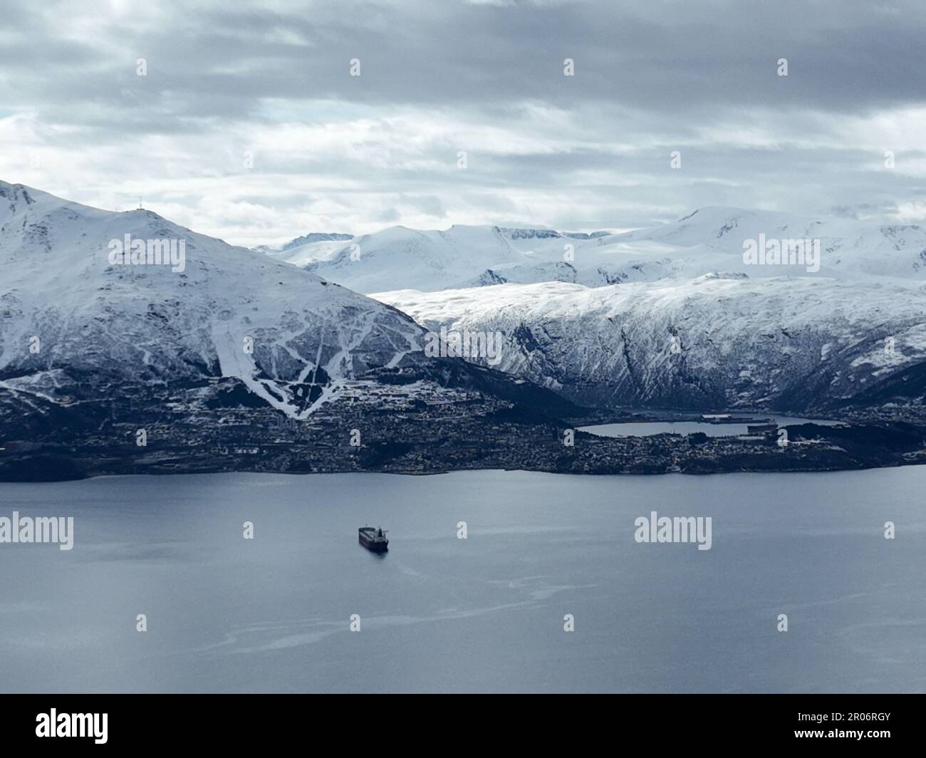 An aerial view of snow-capped mountains near a body of water in Narvik ...