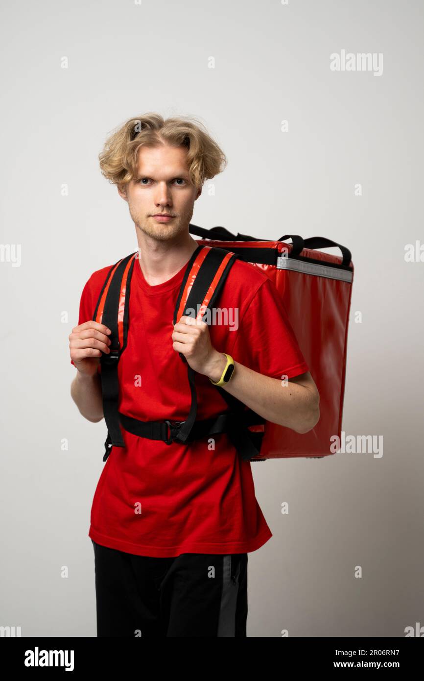 Courier delivers groceries home. Delivery man in red uniform with a ...