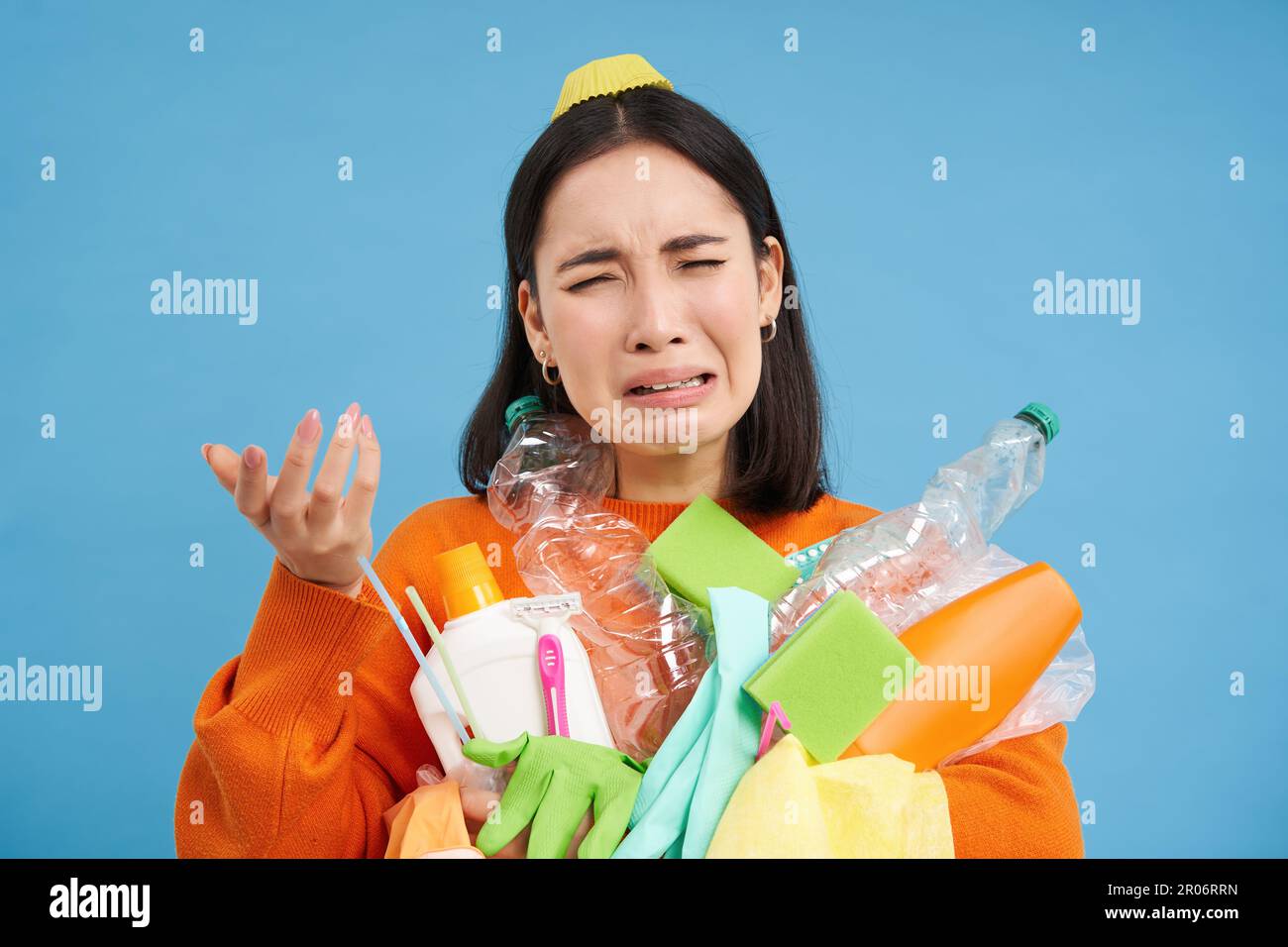 Crying korean woman complaining, holding garbage, plastic bottles ...