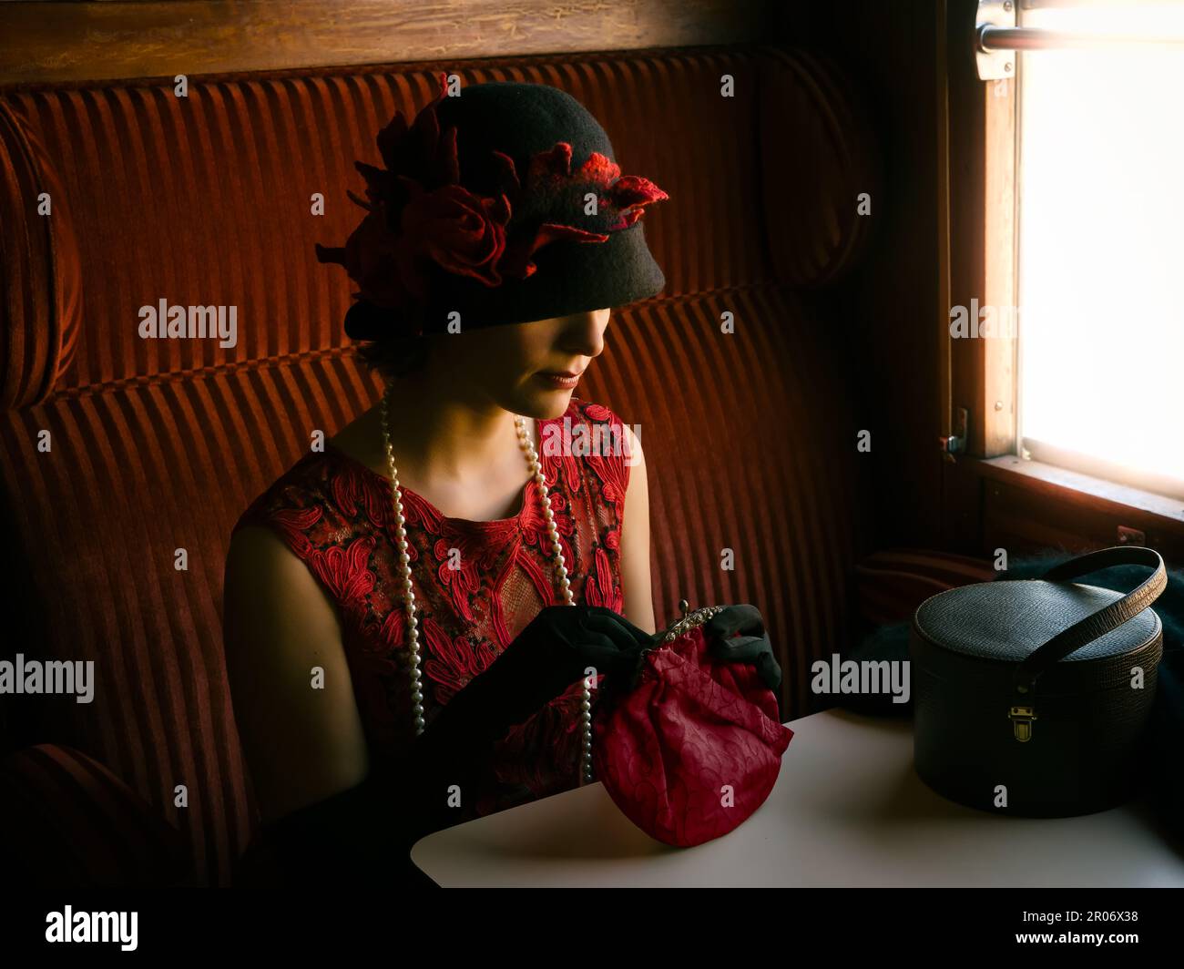 Attractive 1920s woman in red flapper dress and cloche hat posing in ...