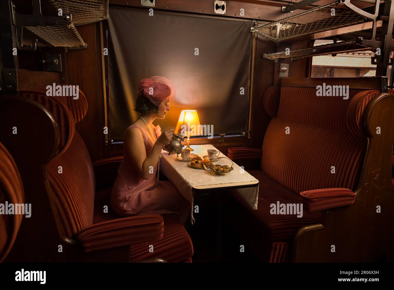 Reenactment scene of a 1920s flapper dress lady enjoying high tea in an ...