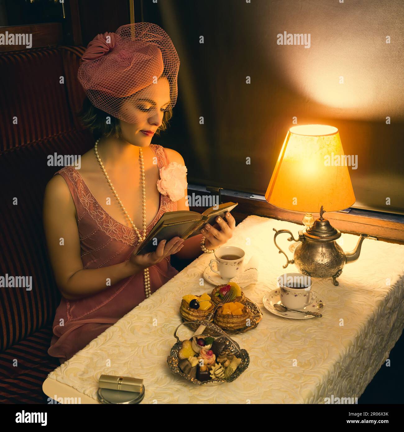 Reenactment scene of a 1920s flapper dress lady enjoying high tea in an ...