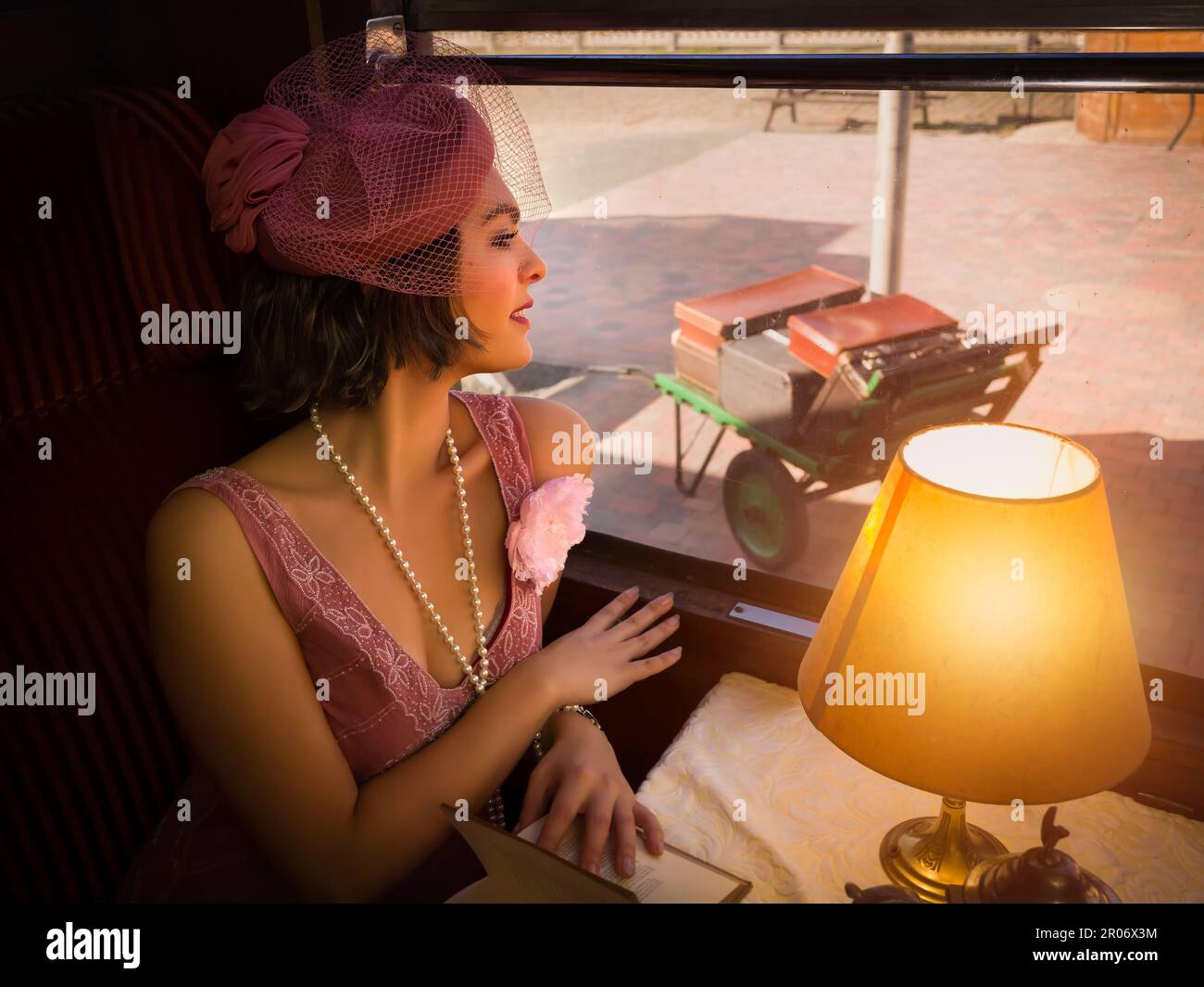 Reenactment scene of a 1920s flapper dress lady enjoying high tea in an ...