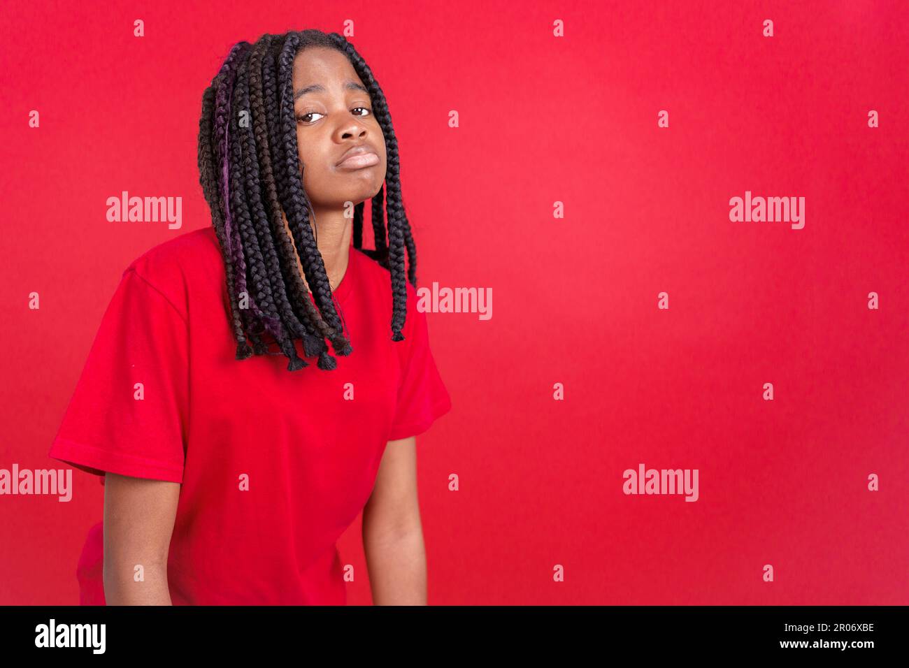 Bored african woman standing and looking at the camera Stock Photo - Alamy