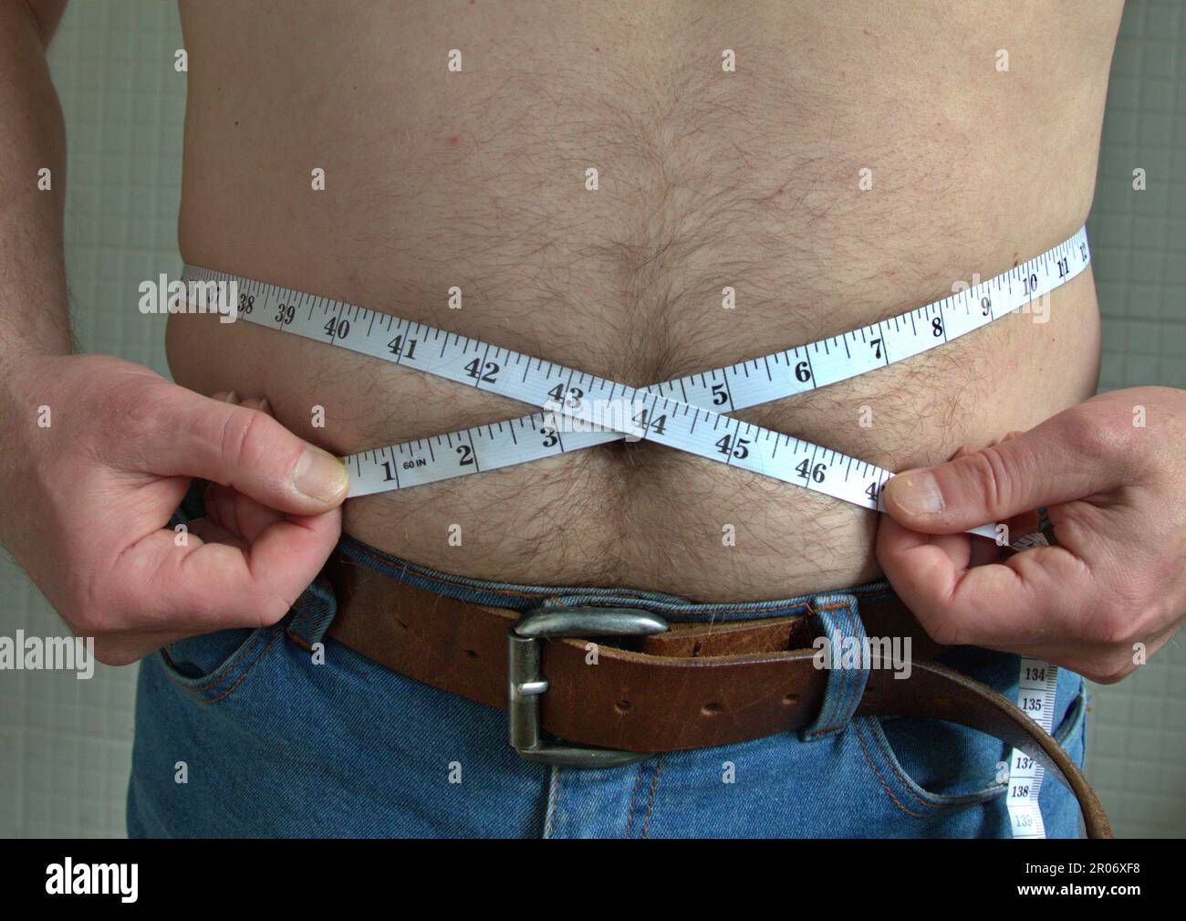 Normal sized male waistline being measured Stock Photo - Alamy
