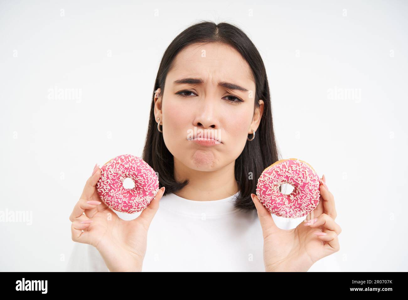 Close up portrait of sad asian woman, upset being on diet, showing two ...