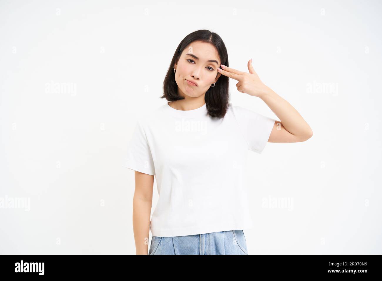 Annoyed asian woman, student shows finger pistol near head, looks ...