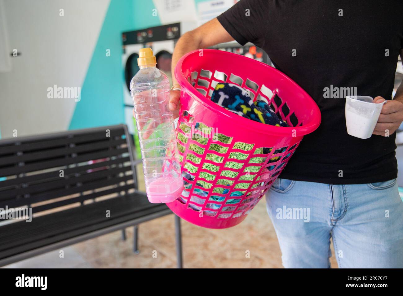 Close-up of a basket with clothes to be washed being held by a man in ...