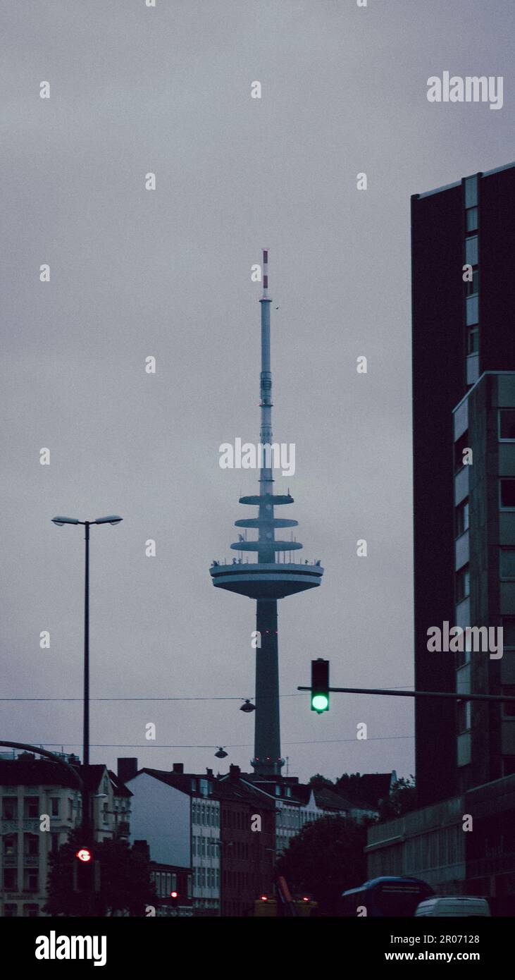 A vertical shot of the Kiel television tower on bustling street corner ...