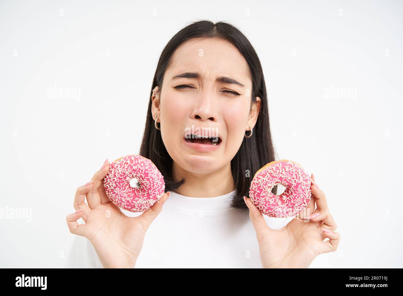 Upset sobbing girl cant eat junk food, shows delicious glazed doughnut ...