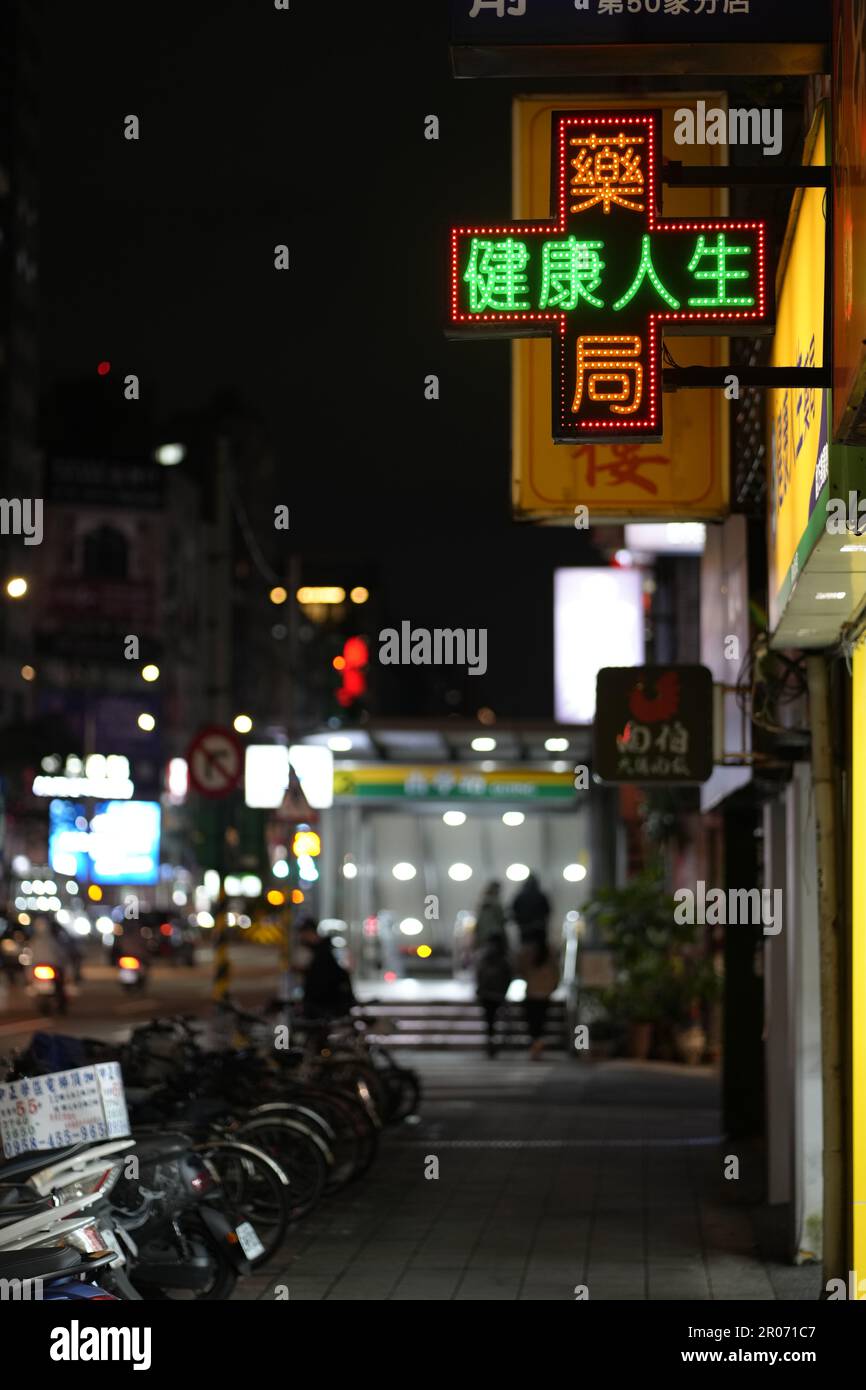 A street sign with neon lights near a parking lof with various ...