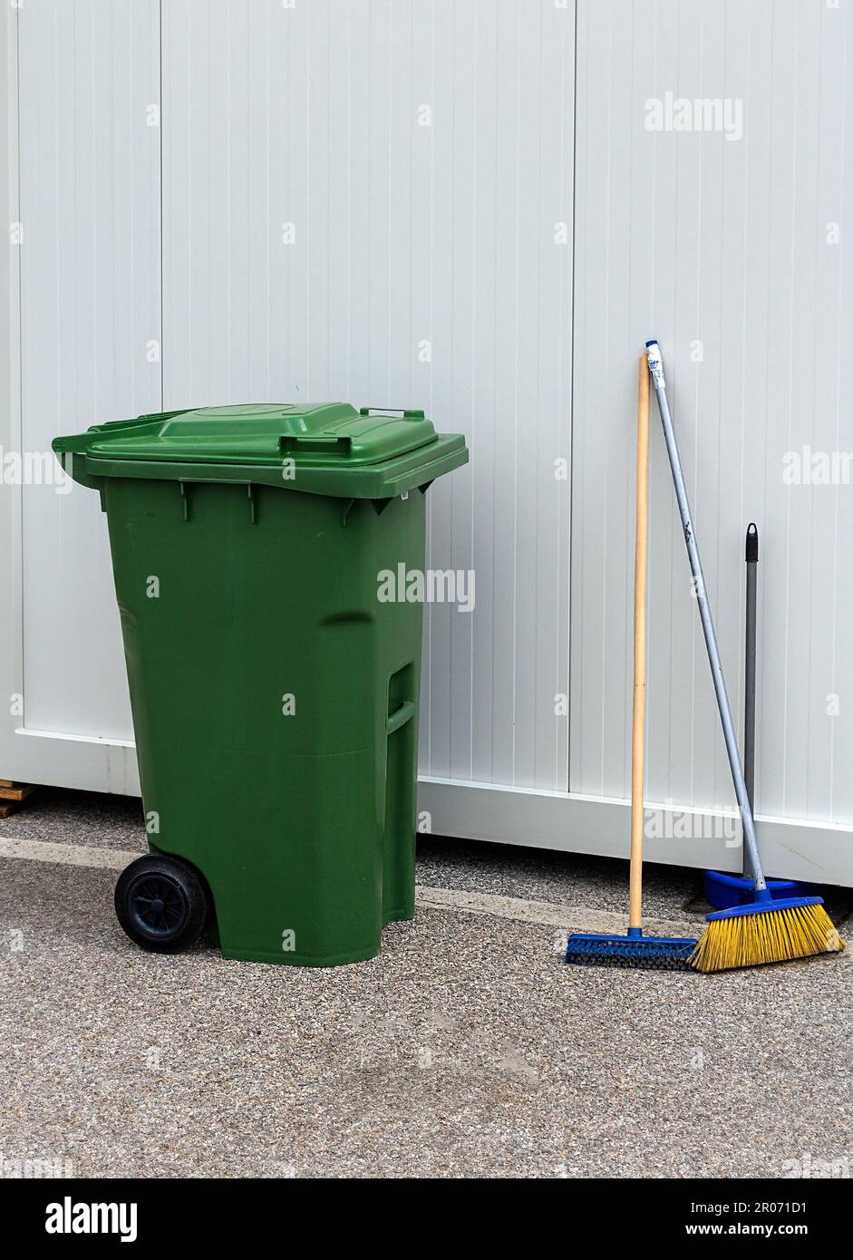 Plastic closed trash bin with cleaning equipment broom and brush ...