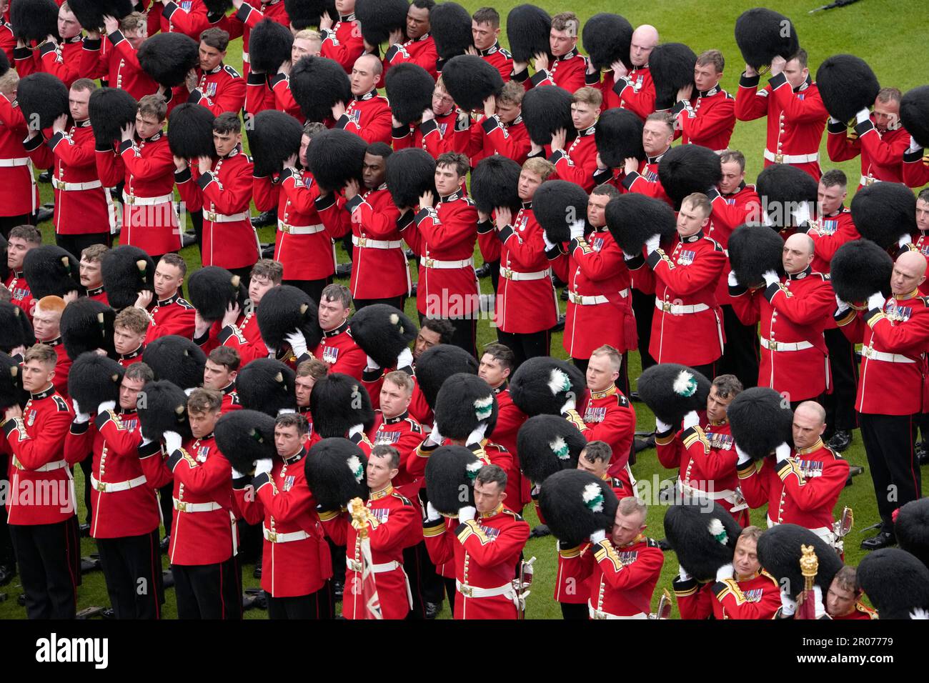 Members of the armed forces remove their headgear at Buckingham Palace ...