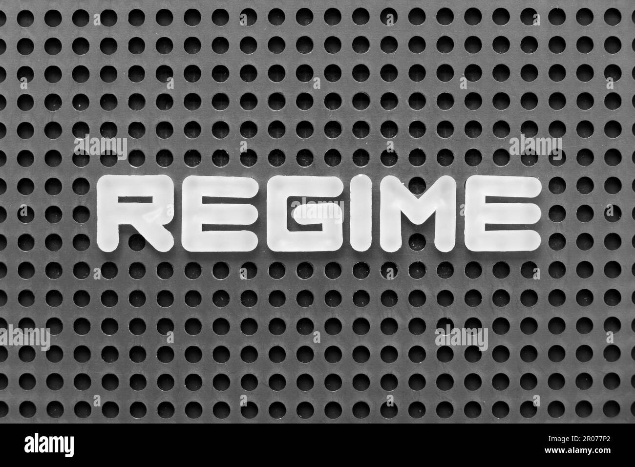 White alphabet letter in word regime on black pegboard background Stock ...