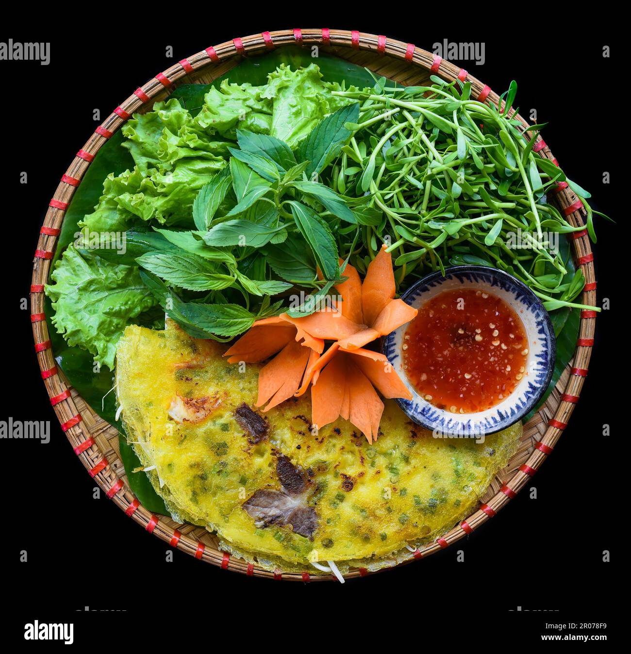 Vietnamese pancake Banh xeo with sea food on black background top view ...