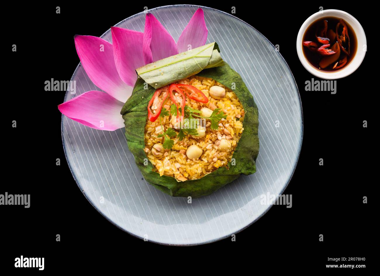 Vietnamese fried rice with vegetables, nuts and shrimps in lotus leaf ...