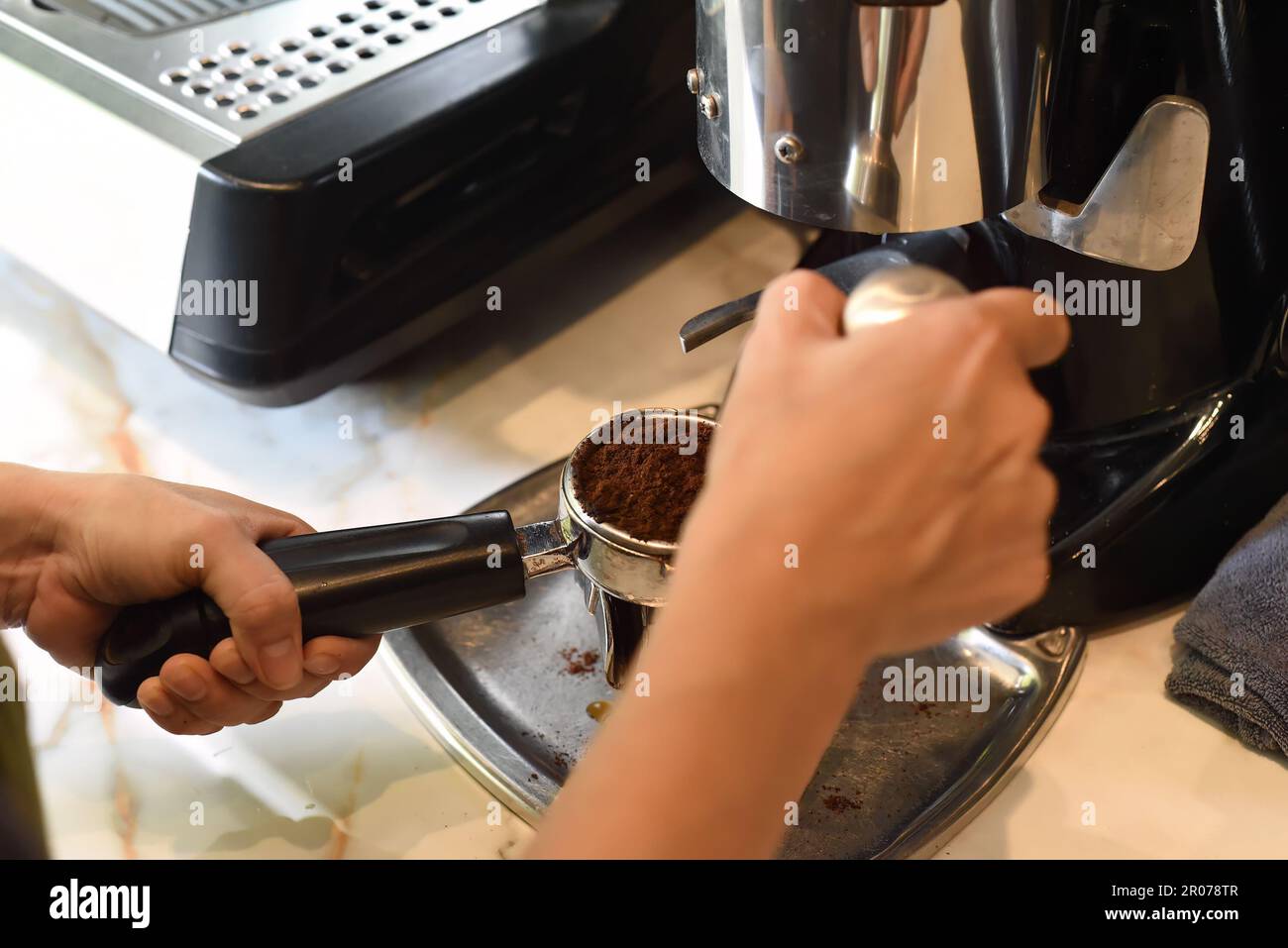 Hands pressing coffee beans for a coffee machine close up Stock Photo ...