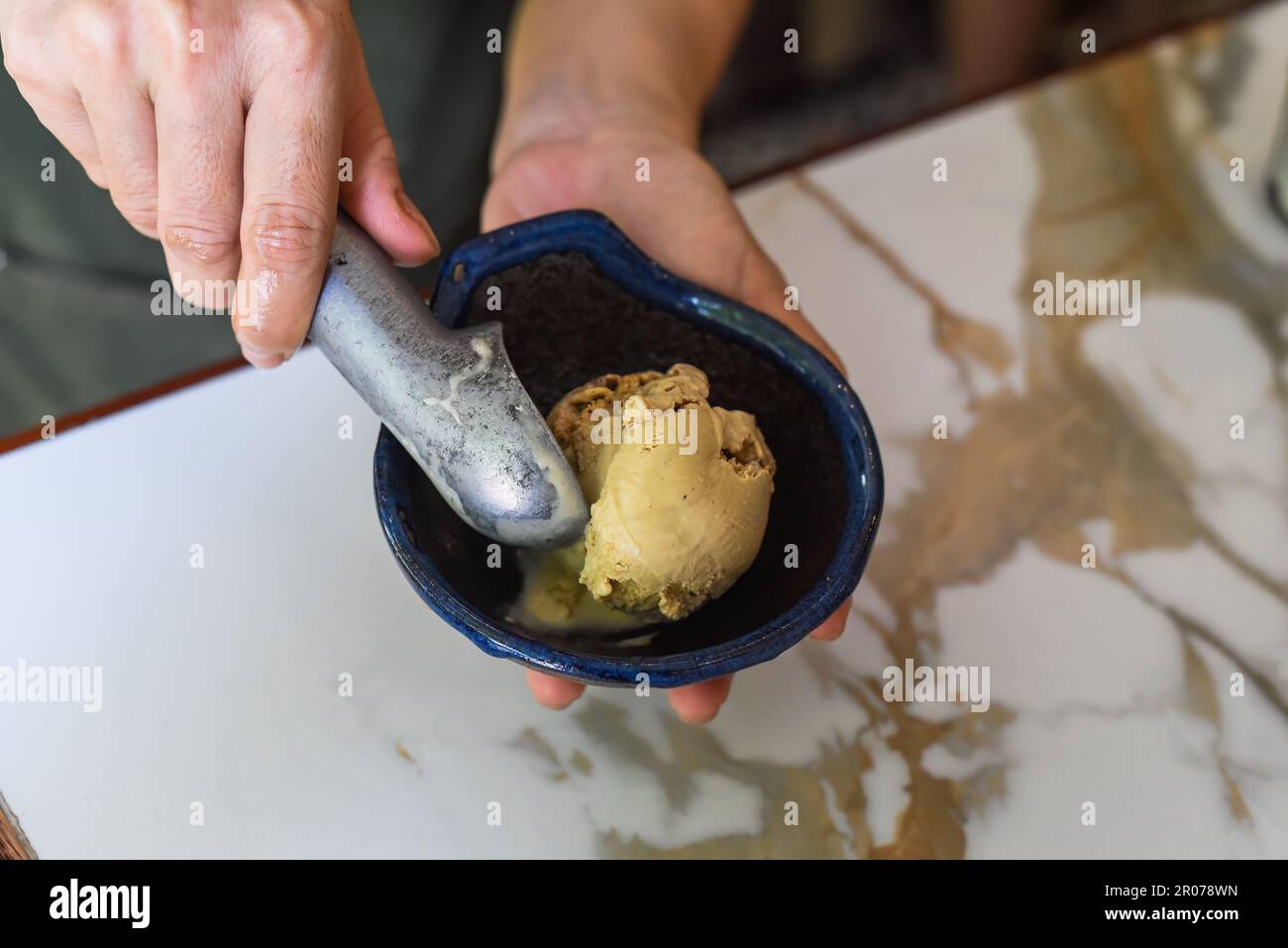 hand scooping a scoop of ice cream into a spoon in fridge Stock Photo ...