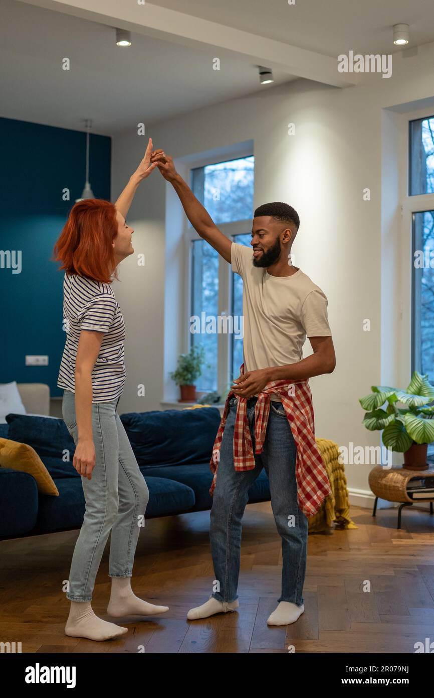 Loving young diverse couple dancing romantic dance in modern bedroom ...