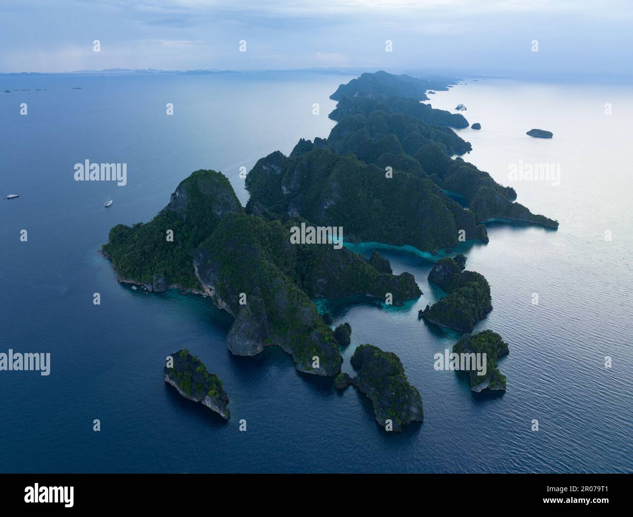 Coral reefs surround the rugged limestone islands that rise from Raja ...