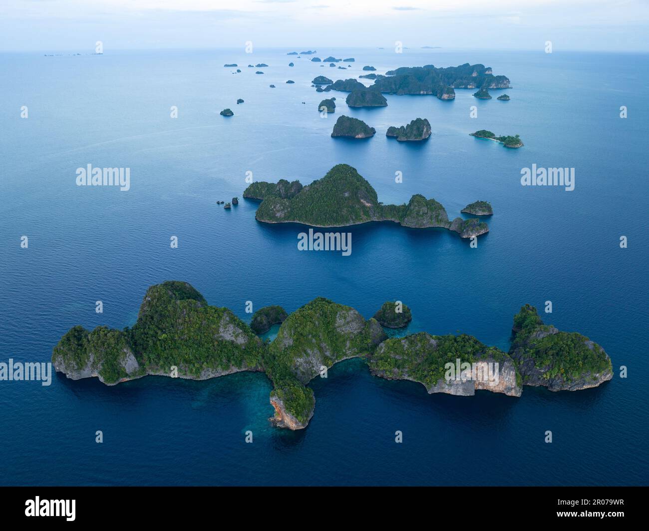 Coral reefs surround the rugged limestone islands that rise from Raja ...