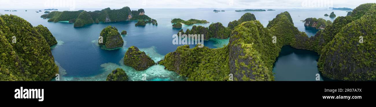 Coral reefs surround the rugged limestone islands that rise from Raja ...