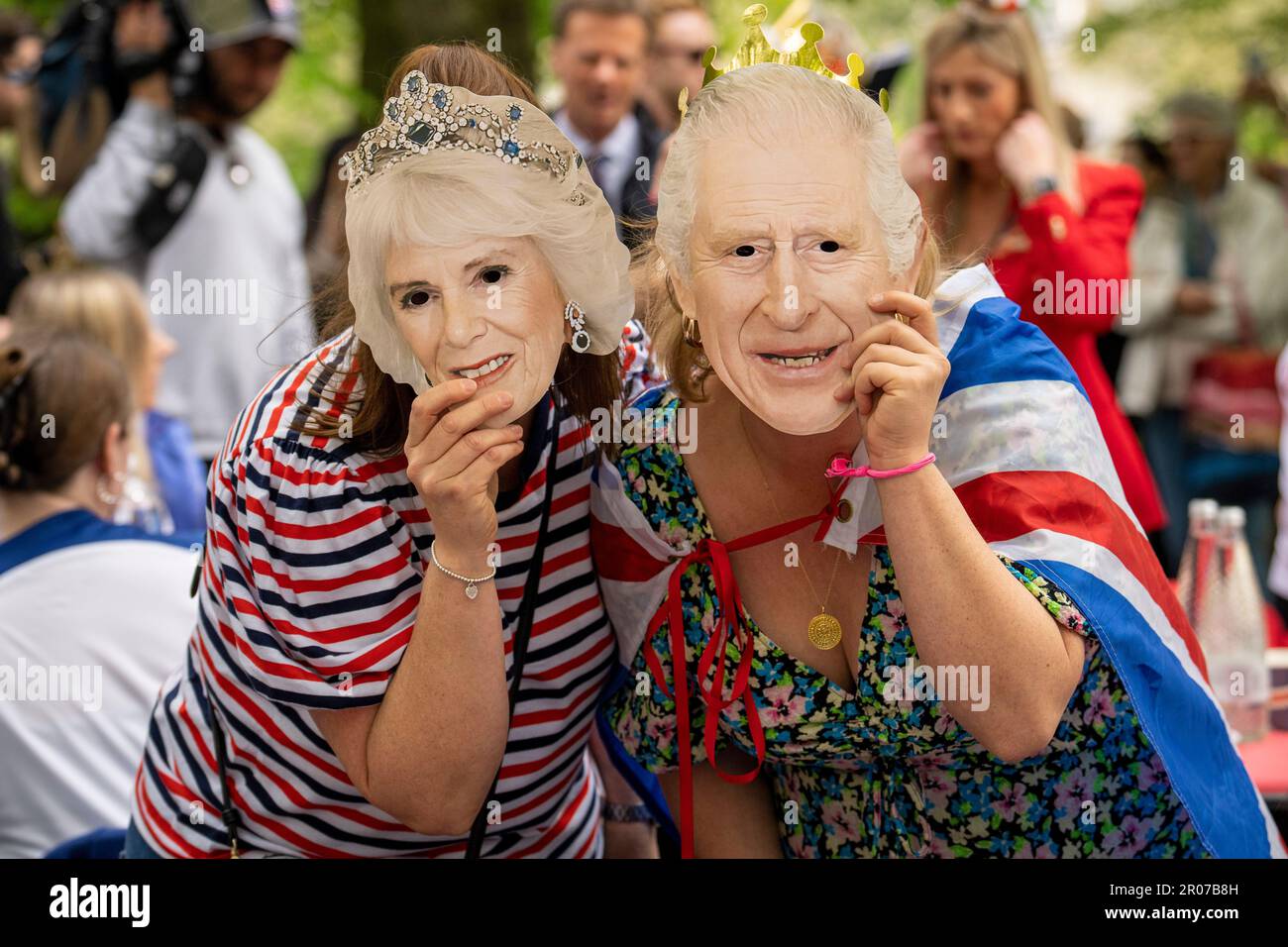 Women pose with masks depicting King Charles III and Queen Camilla ...