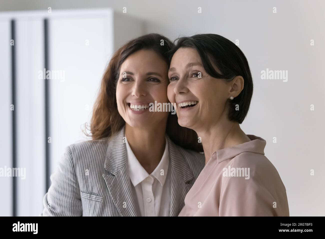 Beautiful mature and young businesswomen colleagues smiling at ...