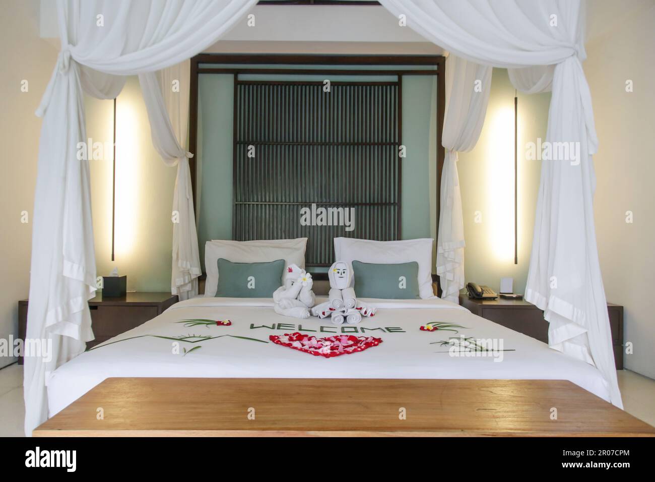 Welcome flowers and towels arrangement on the bed in luxury hotel on ...