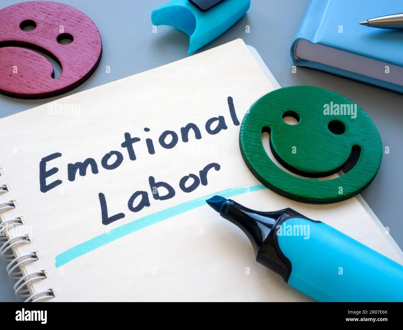 Notepad with handwritten lettering emotional labor and green emoticon ...