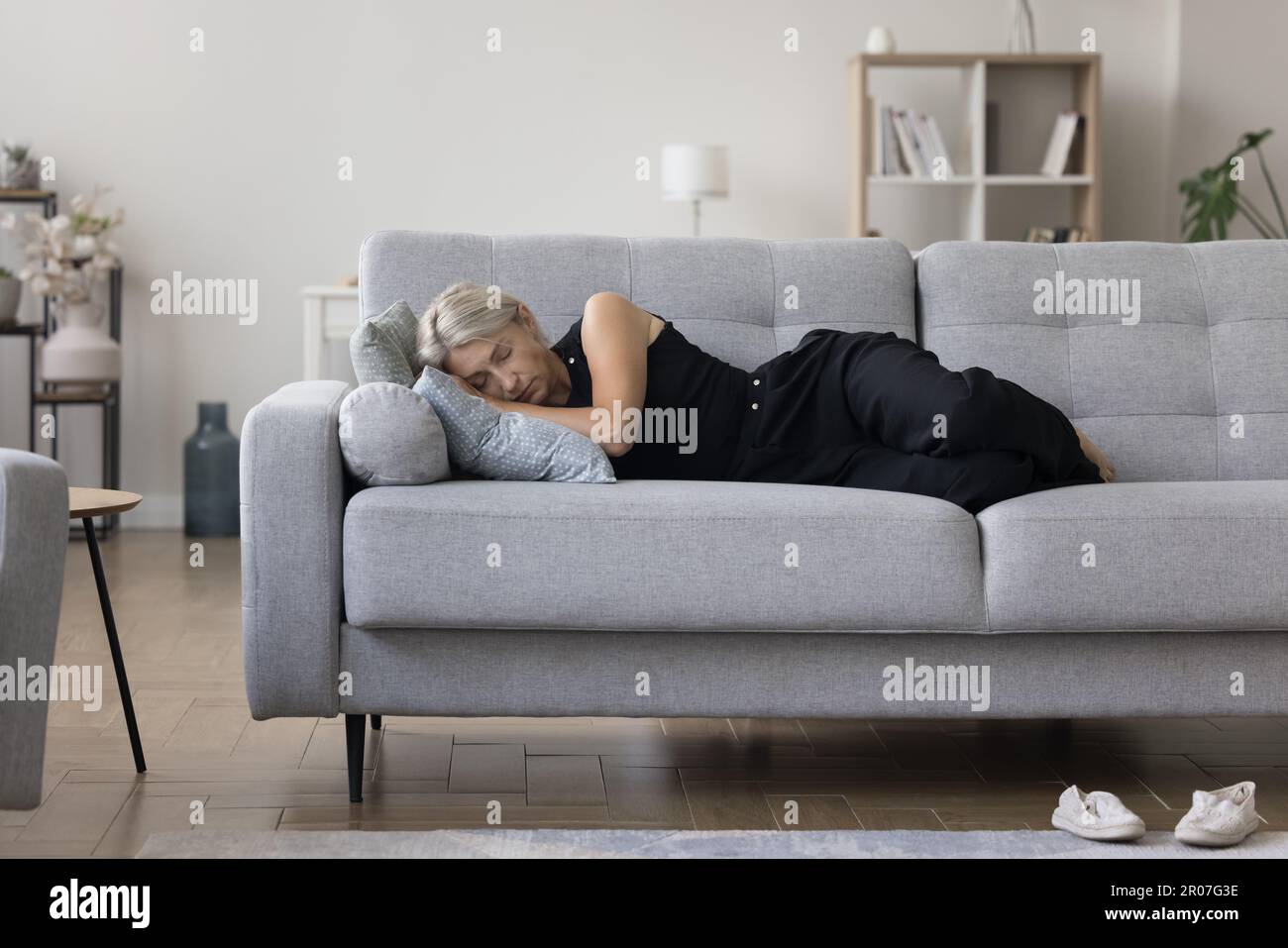 Calm homeowner woman lying on side on comfortable sofa Stock Photo - Alamy