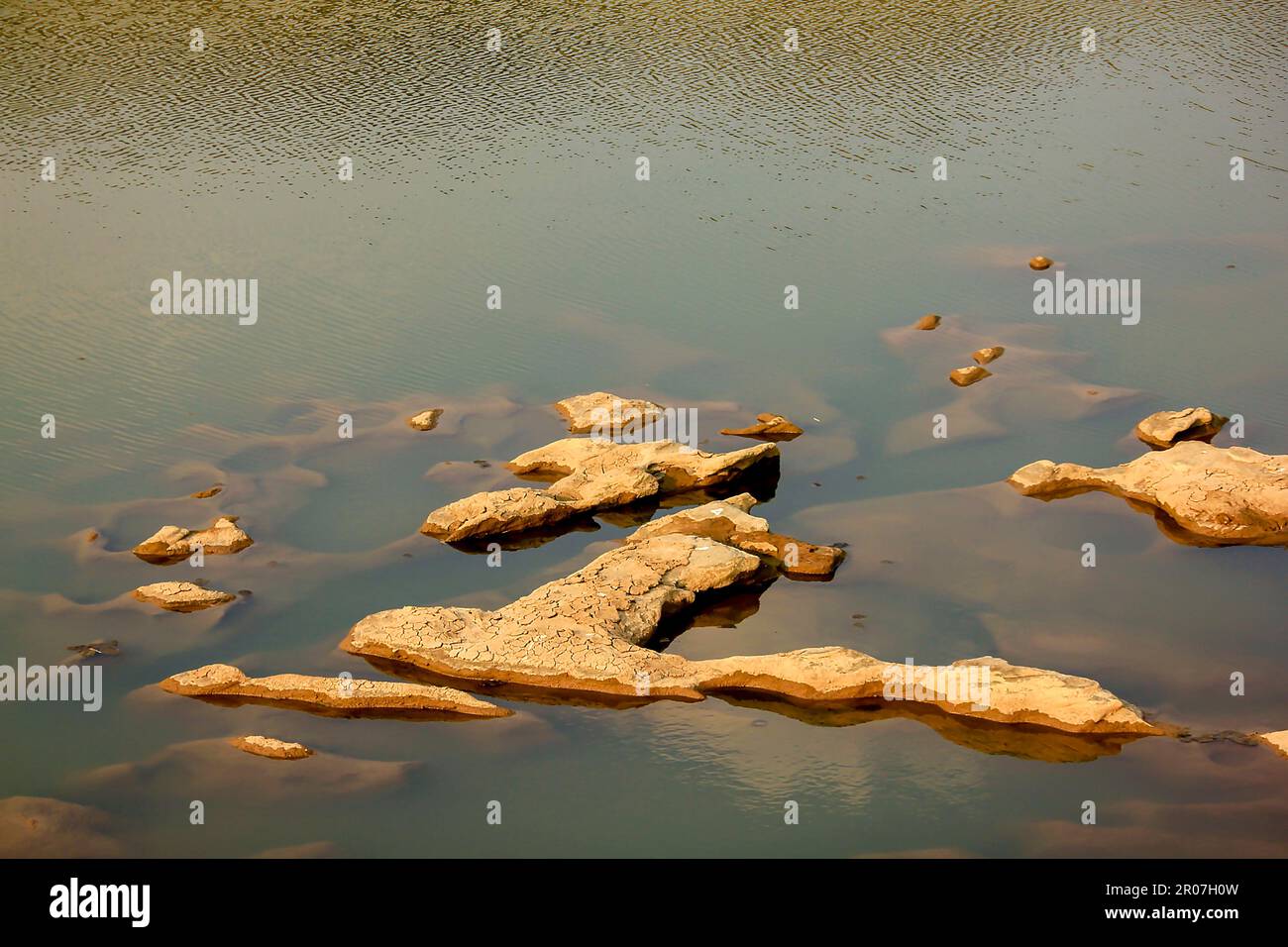Rocks above the surface of the pond Stock Photo - Alamy