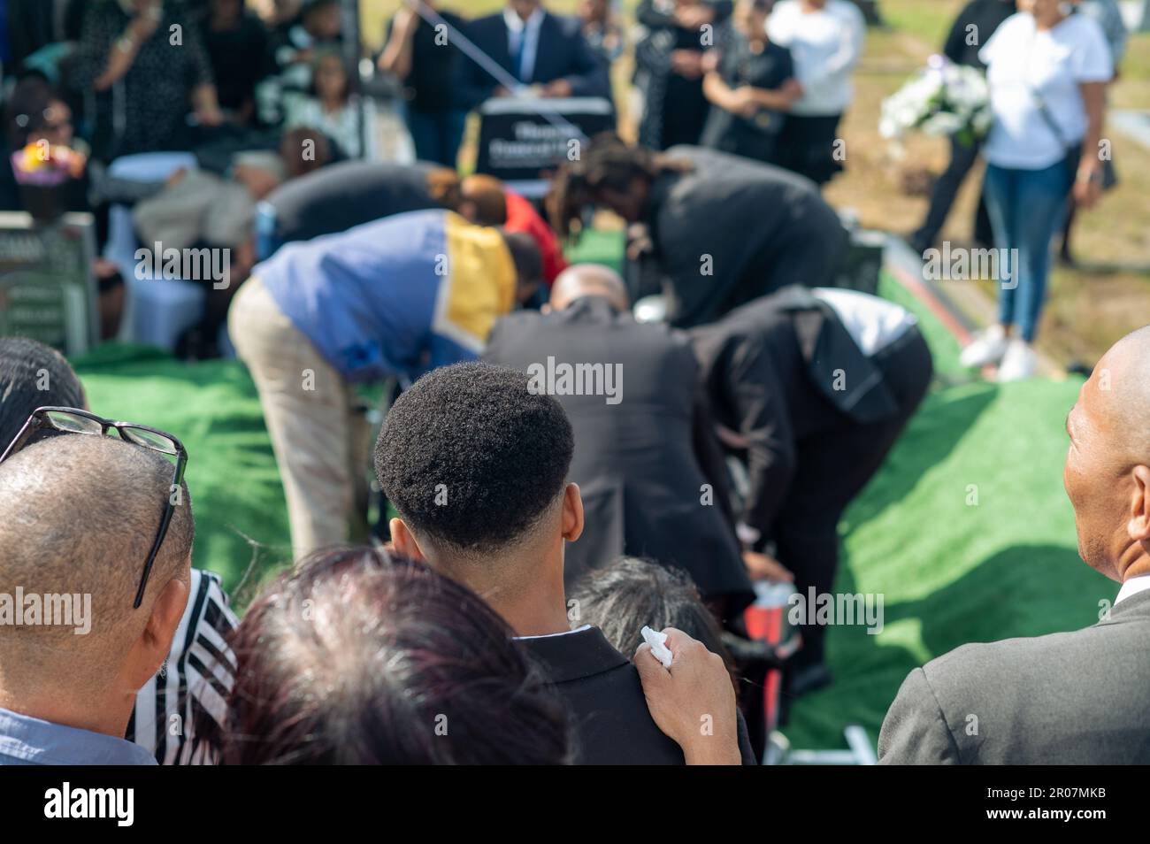 Rear view of group of people at funeral service Stock Photo - Alamy