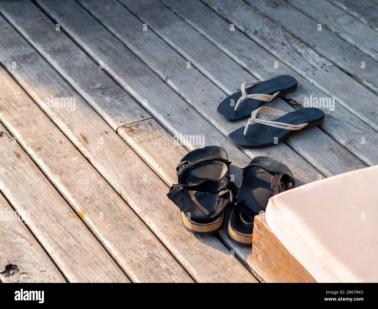 Empty black sand-stained man and woman sandals were taken off, on the ...