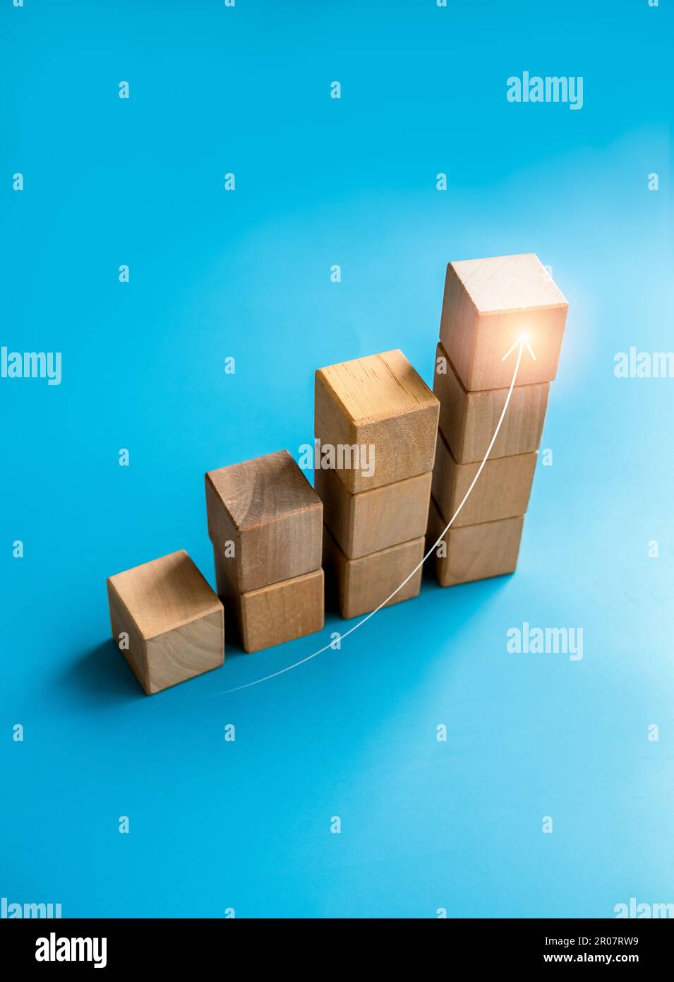 Rising up curved thin arrow draw on wooden cube blocks bar graph chart ...