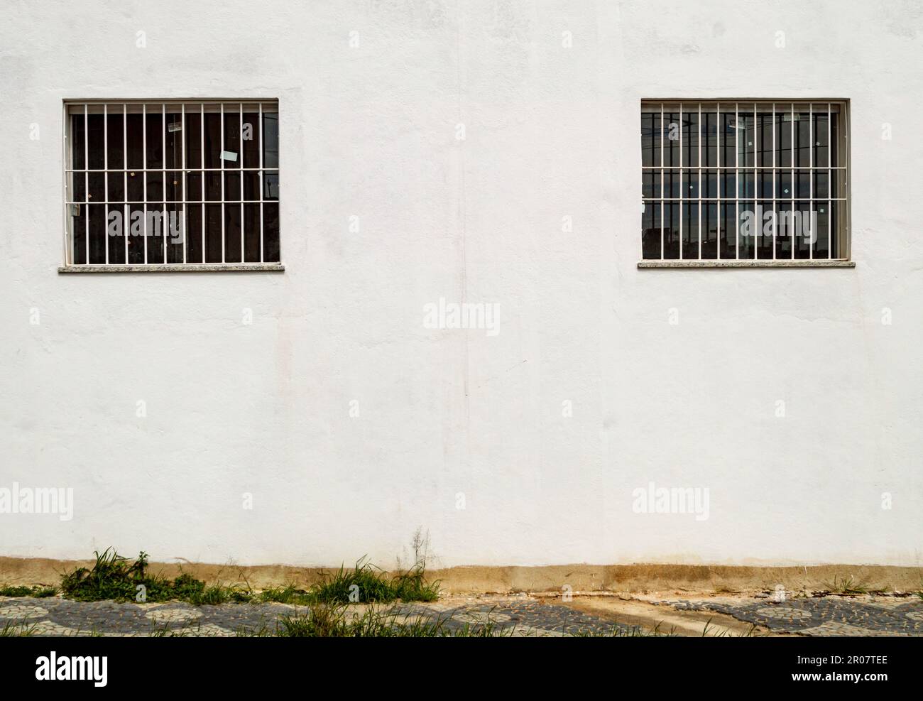 Wall. External white wall with two small windows with bars Stock Photo ...
