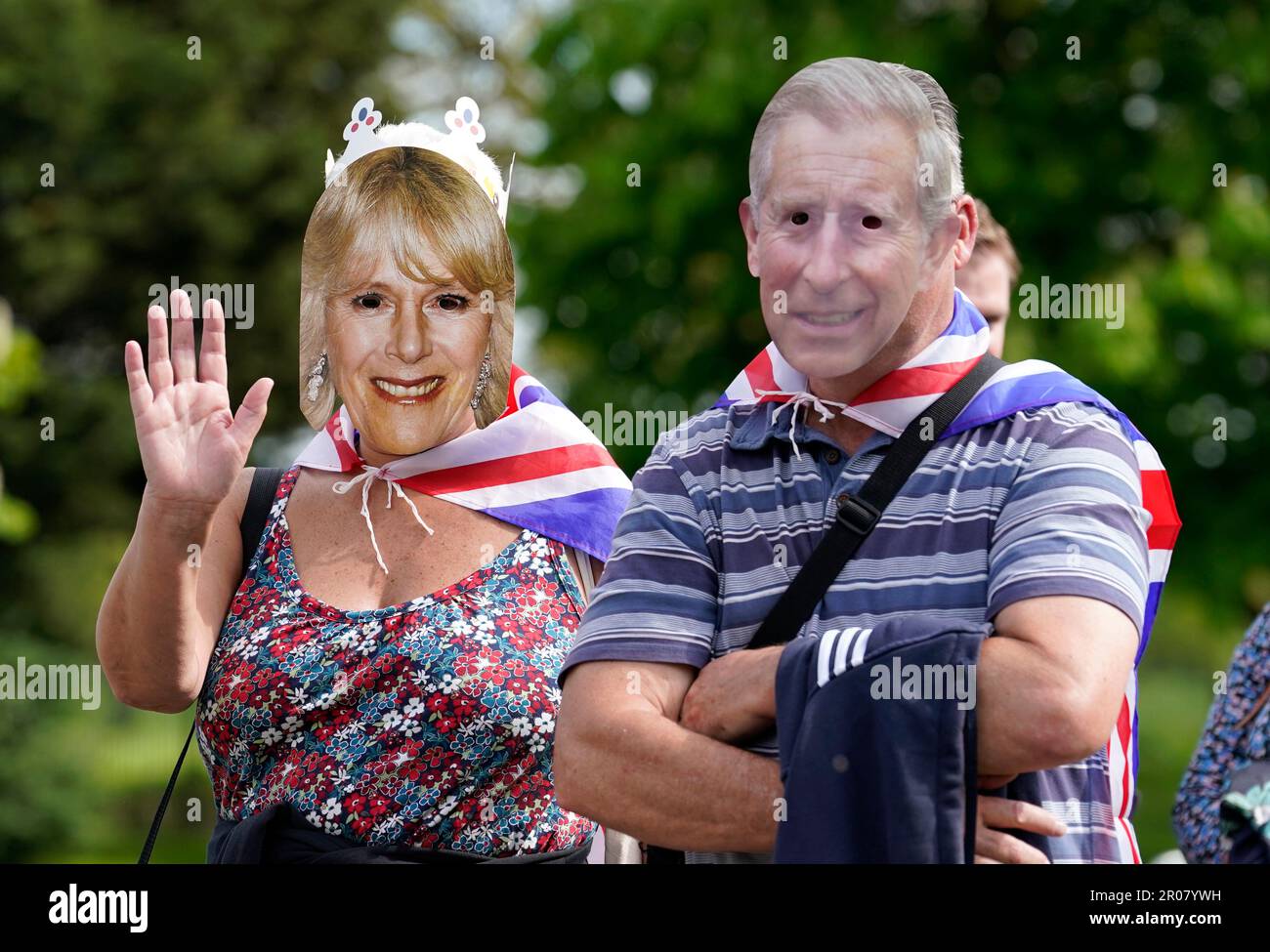 Guests wearing face masks of the King and Queen make their way along ...