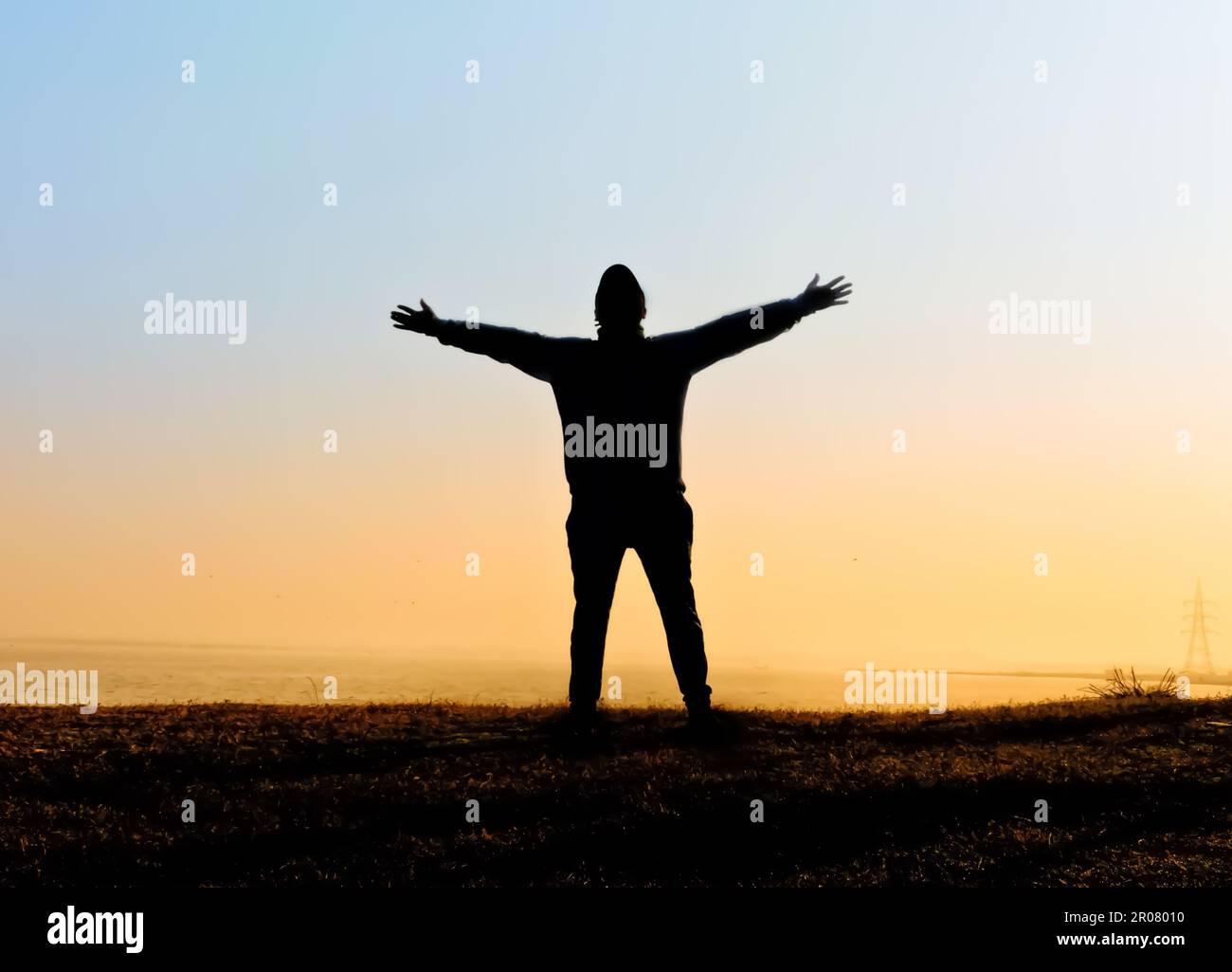 A man opening arms during sunrise Stock Photo - Alamy