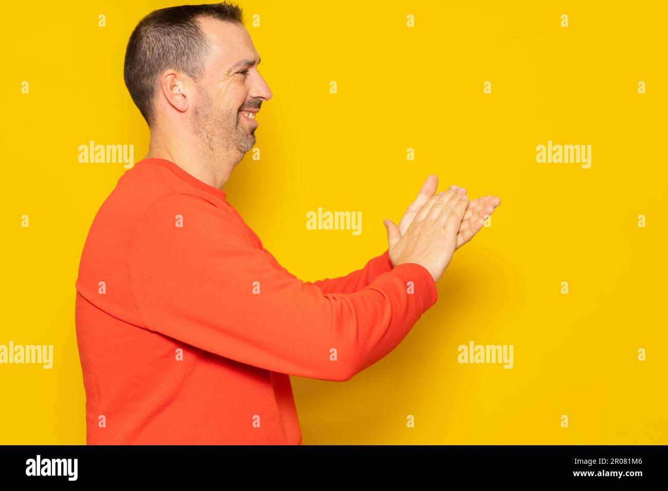 Bearded hispanic man in profile wearing a red jumper feeling happy ...