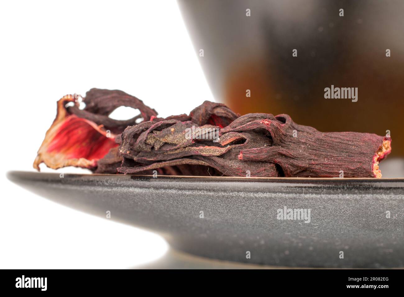 Fragrant karkade tea on saucer with ceramic cup, macro, isolated on ...