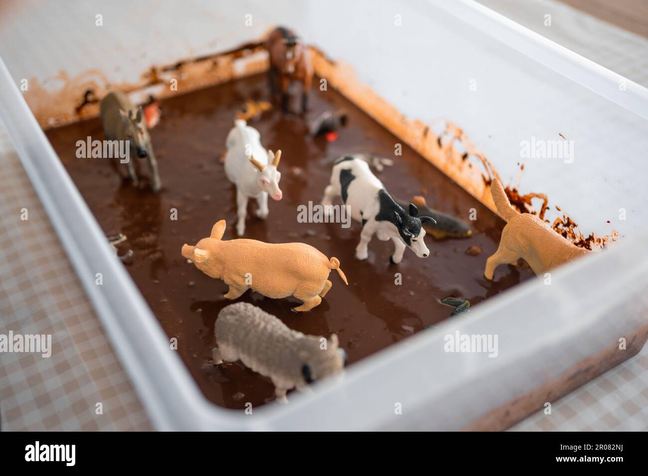 Homemade chocolate sensory mud with farm animal models. Sensory ...