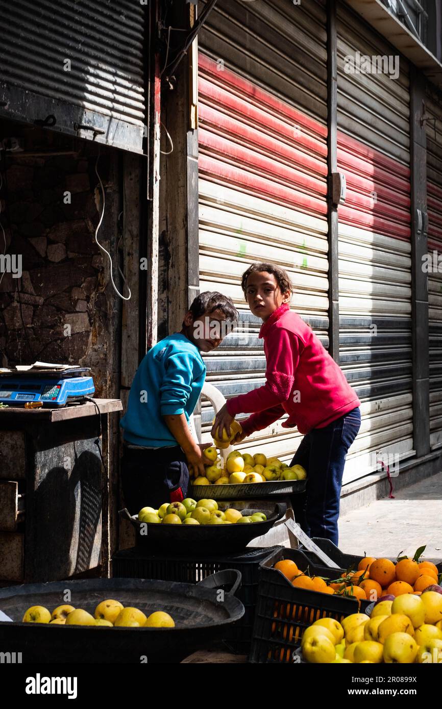 Damascus, Syria - April, 2023: A boy and a girl selling fruits on ...