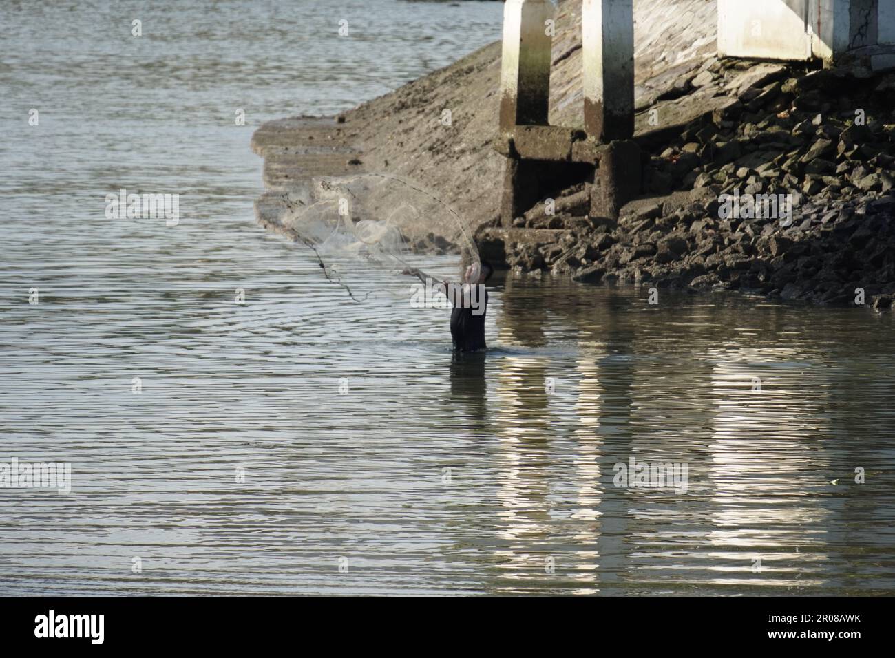 Photo of a man casting a fishing net Stock Photo - Alamy