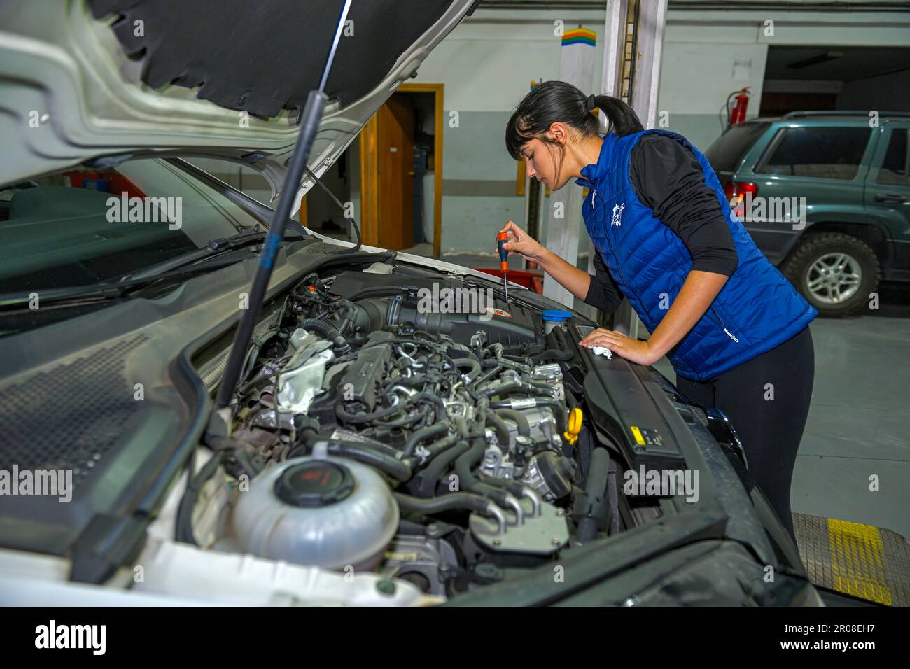 Young female mechanic, working on the repair of a car engine Stock ...