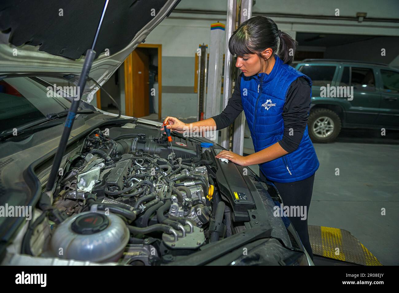 Young female mechanic, working on the repair of a car engine Stock ...