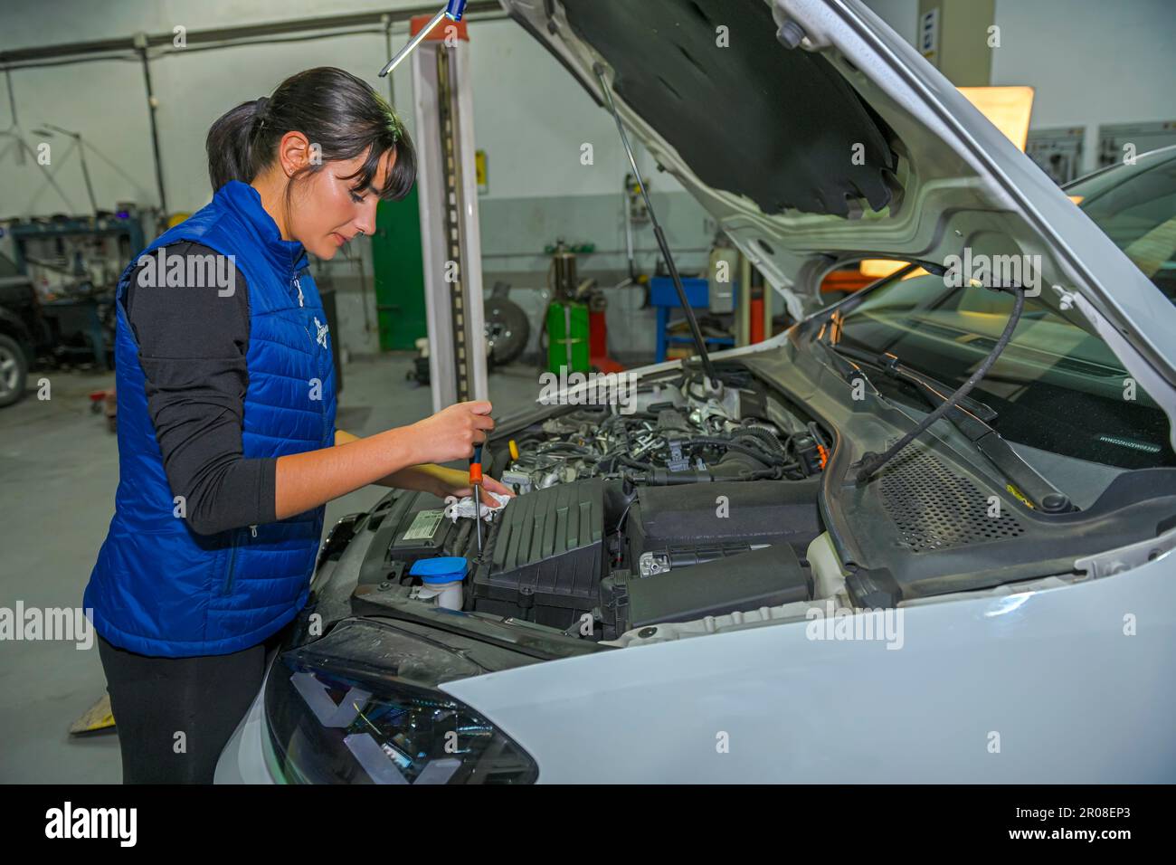 Young female mechanic, working on the repair of a car engine Stock ...